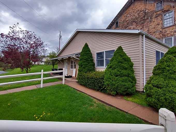 This cozy cottage-style building with its white fence looks like it belongs in a Norman Rockwell painting.