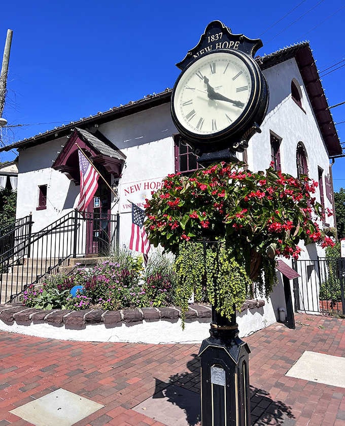 That town clock stands proud like a faithful sentinel, marking time since 1837 with flowers blooming at its feet.