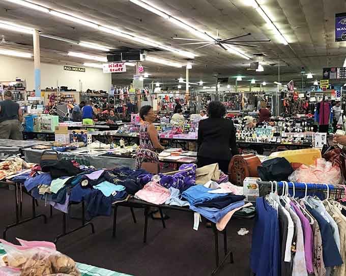 Clothing tables stretch into the distance while shoppers hunt through racks like they're mining for fashion gold.