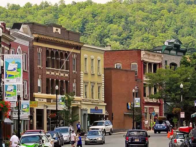Forested hillsides embrace colorful storefronts in a town where nature and commerce shake hands every single day.