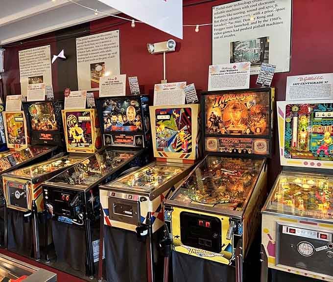 Classic pinball machines line up like old friends, their colorful artwork featuring Indiana Jones and other beloved adventure heroes.