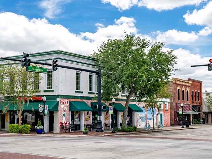 Classic brick buildings with green awnings create a timeless downtown scene where you half expect to see a soda fountain.