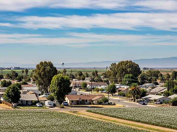 Farmland stretches to distant mountains, showing how Corcoran sits peacefully in California's agricultural heartland, quiet and productive.
