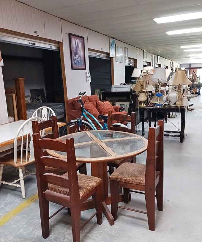 Clean aisles and organized booths showcase furniture and lamps in a well-lit space perfect for serious antique hunting.