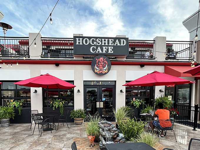 Red umbrellas and outdoor seating create the perfect stage for HogsHead's smoky performances.
