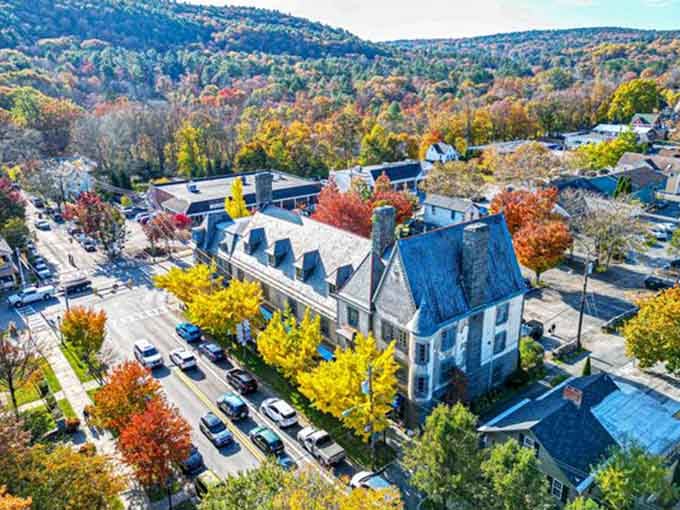 Fall foliage explodes in reds and golds across rooftops, nature's way of showing off for the camera.