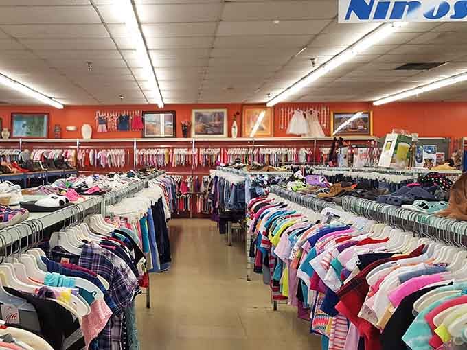 Bright orange walls energize this cheerful space where kids' clothes hang in every shade imaginable, ready for growing families.