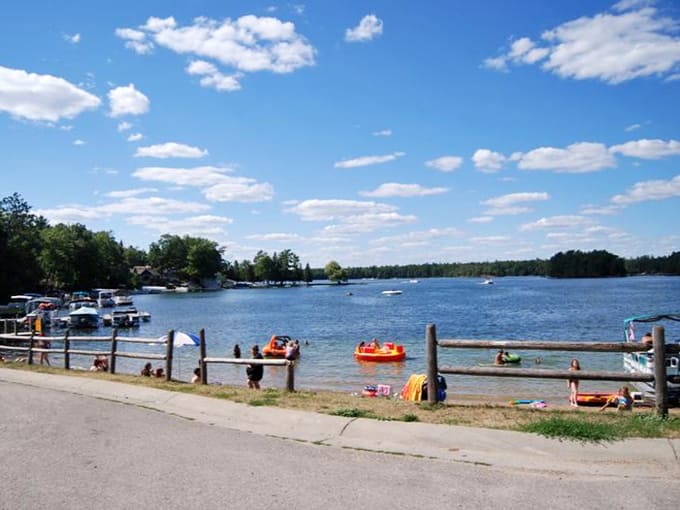 Summer fun splashes across this lake view, where orange rafts bob and families create memories that'll last forever.