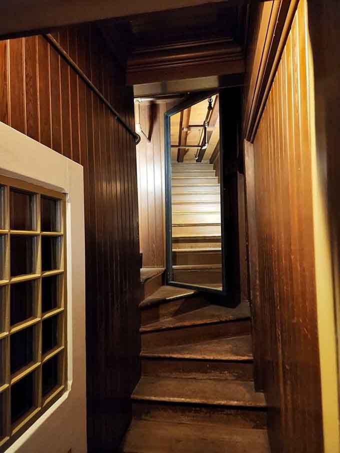 A narrow staircase twists upward into darkness, leading nowhere and everywhere at once in this architectural puzzle box.