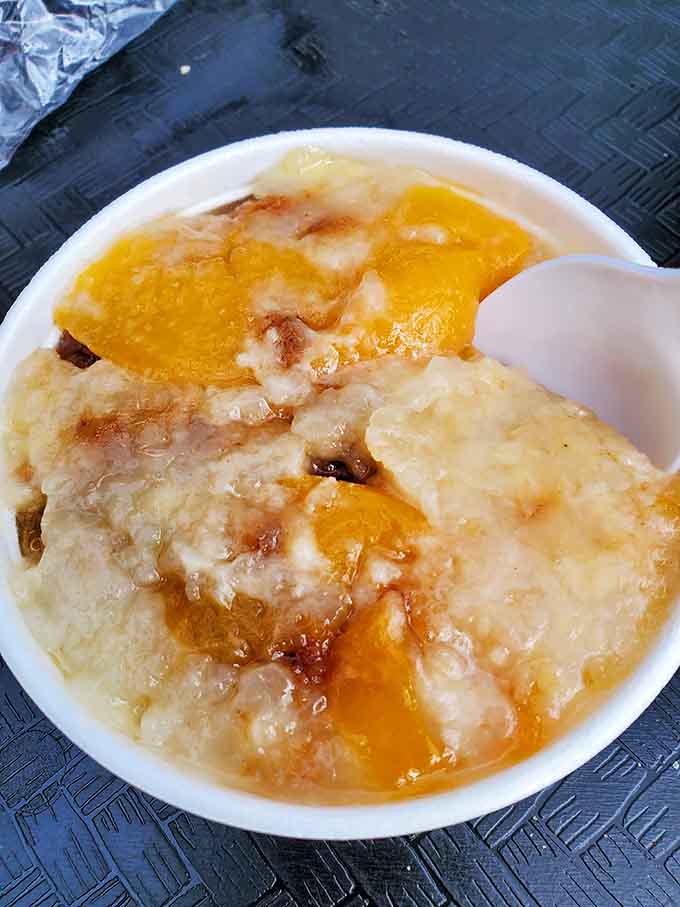 Peach cobbler that looks like summer decided to take a warm, comforting nap in a bowl.