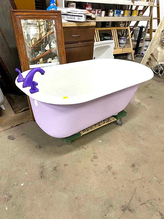The vintage claw-foot tub with quirky purple fixtures is begging for a bubble bath and a glass of wine after installation.