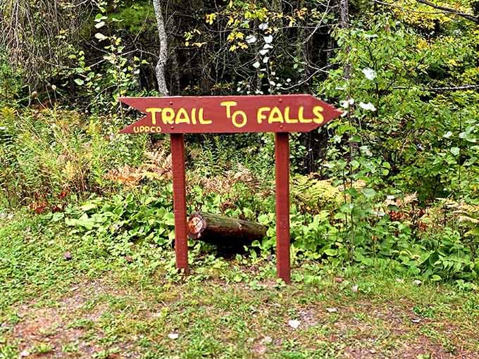 The cheerful trail sign promises exactly what it delivers: a short walk to something absolutely worth seeing.