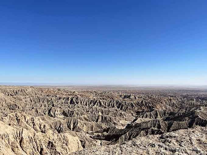 The badlands stretch endlessly, carved by time into ridges that look like nature's own abstract sculpture garden.