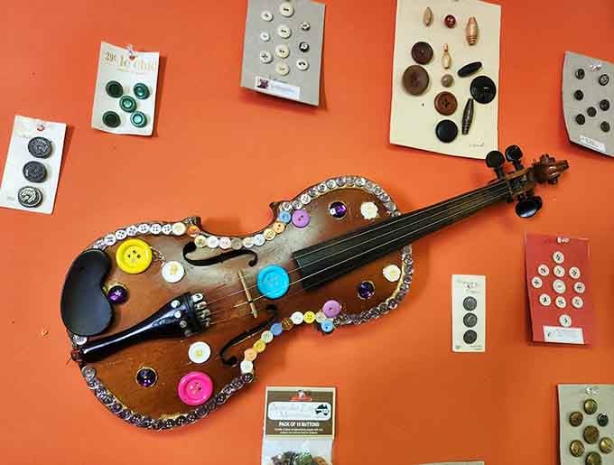 This delicate violin gets the button treatment, proving no instrument is safe from artistic transformation here.