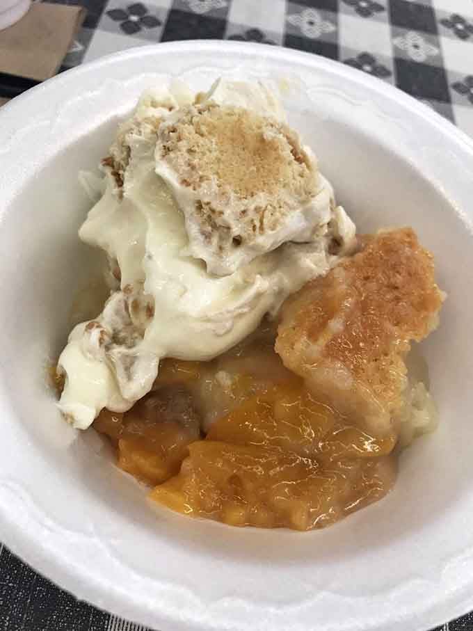 Peach cobbler topped with whipped cream: the kind of dessert that makes you glad you wore elastic waistband pants.