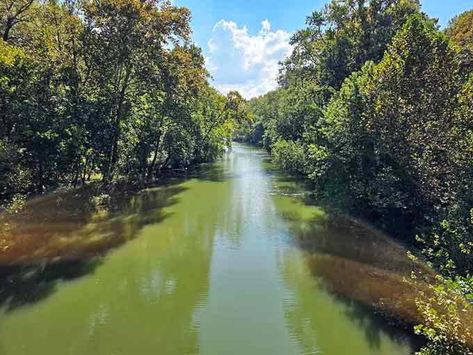 The river flows peacefully now, its waters reflecting trees instead of the chaos it once unleashed upon Rose Island.