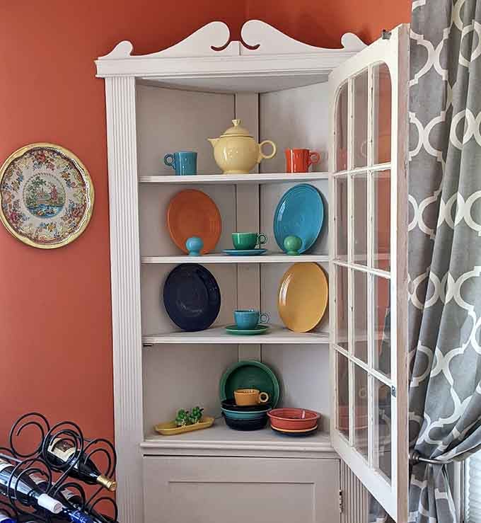 A pristine cabinet displaying vintage dishware proves that presentation matters, even for things gathering dust since Eisenhower.
