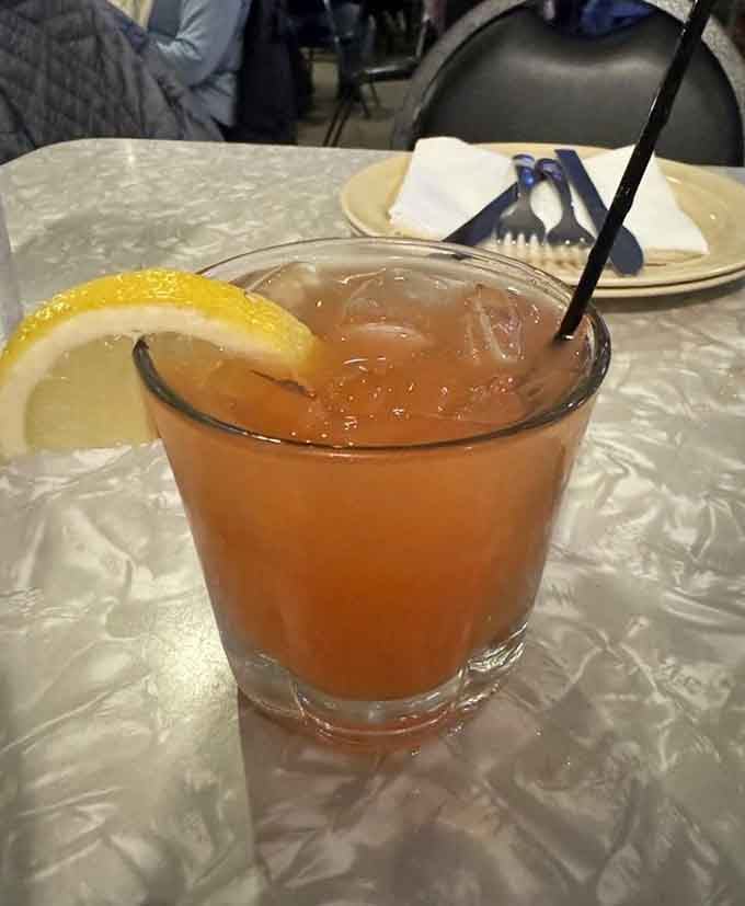 A cold drink with citrus garnish pairs beautifully with hot pizza, creating the kind of simple pleasure that never ages.