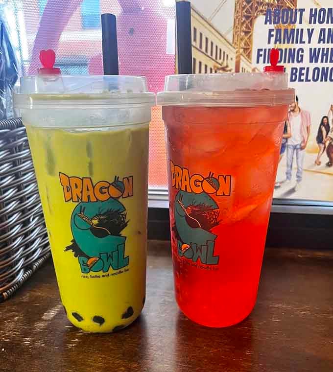 Boba tea in branded cups, one yellow and mysterious, one red and bold, both ready to refresh your soul.