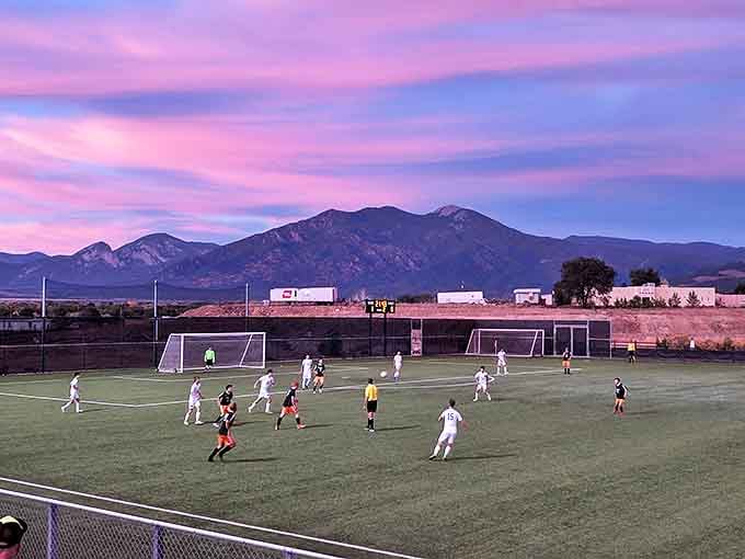 Soccer under sunset skies with mountain backdrops &ndash; where everyday athletes become momentary gods in the golden light of evening.