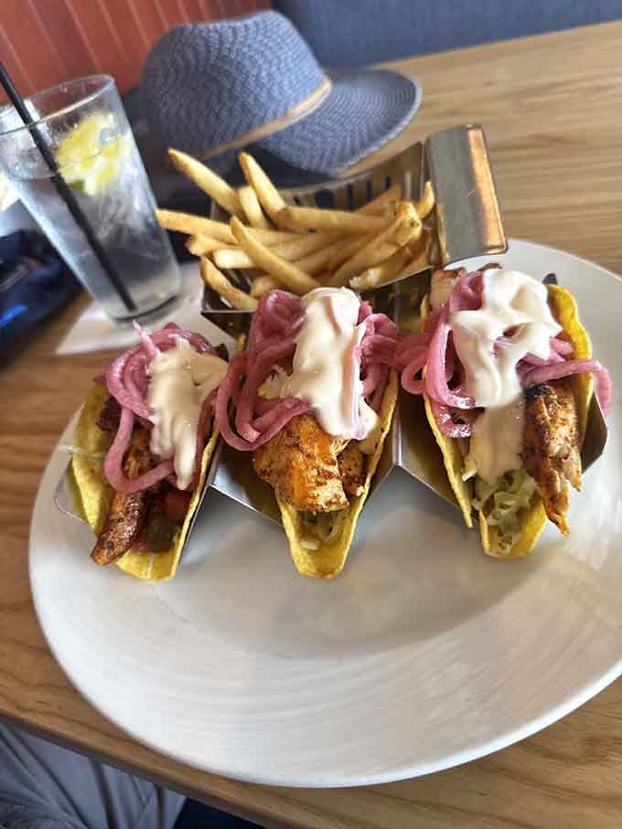 Fish tacos topped with pickled onions and drizzled sauce, proving that Maryland seafood plays well with everyone.