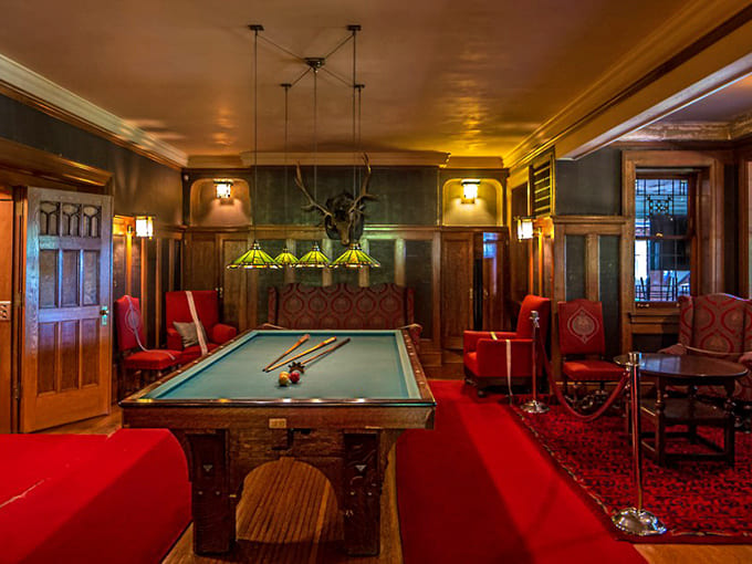 The billiards room proves that the wealthy knew how to relax in style, complete with Tiffany lamps overhead.
