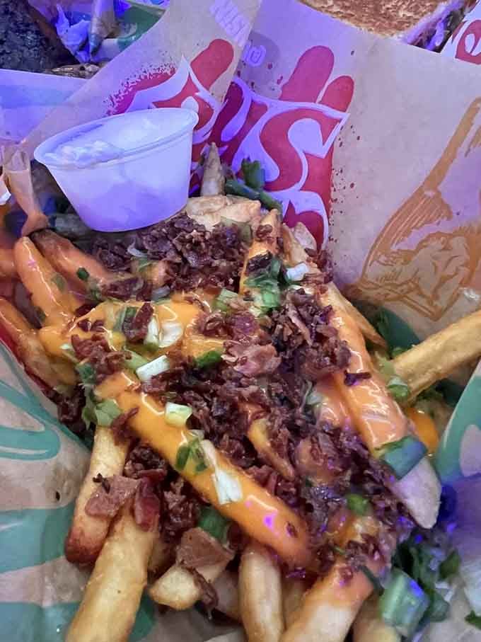 Loaded fries buried under cheese, bacon, and green onions turn a side dish into the main event.