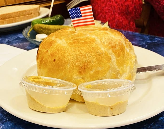 The knish comes with its own flag, as if claiming territory on your plate forever.