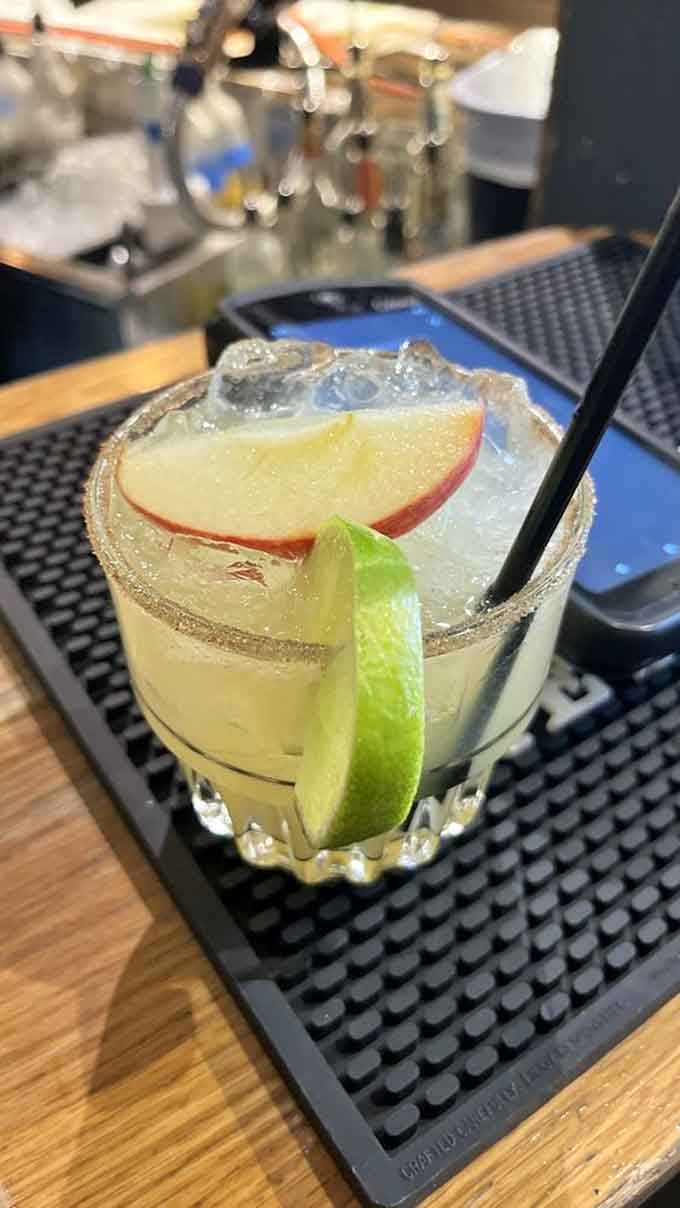 That apple slice garnish is working harder than most people do on Monday mornings to make this margarita Instagram-worthy.