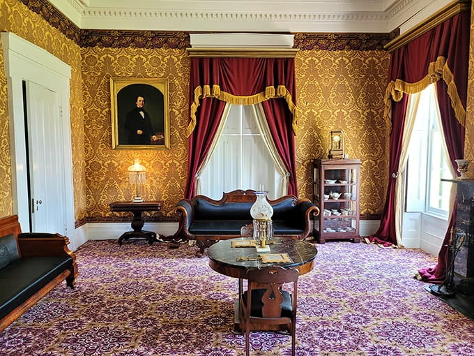 Rich gold wallpaper and plum-colored curtains create a parlor so luxurious you'd hesitate to actually sit down anywhere.