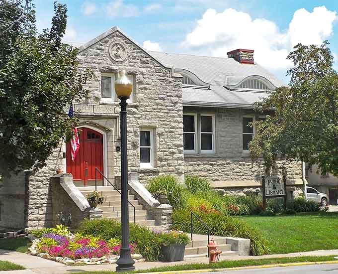 Not just books but community cornerstone &ndash; the limestone library with its vibrant garden welcomes readers with architectural charm and a splash of color.