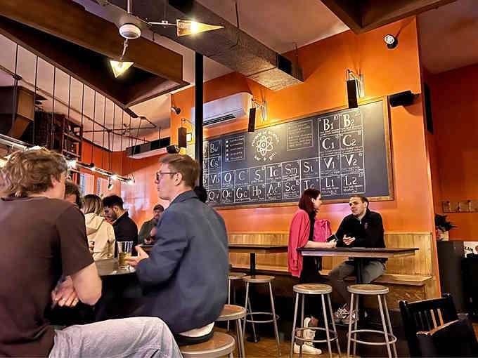 The periodic table looms overhead while diners enjoy their meals, making everyone feel slightly smarter while eating burgers.