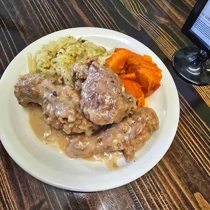 Smothered pork chops swimming in gravy with sweet potatoes: comfort food that actually earns the title legitimately.
