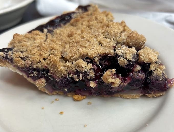 Blueberry crumble pie with a topping so generous it practically qualifies as architectural achievement in baked goods.