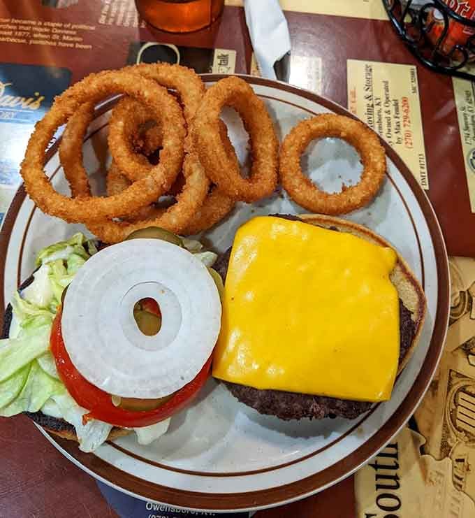 Golden onion rings stacked high alongside a cheeseburger that means serious business today.
