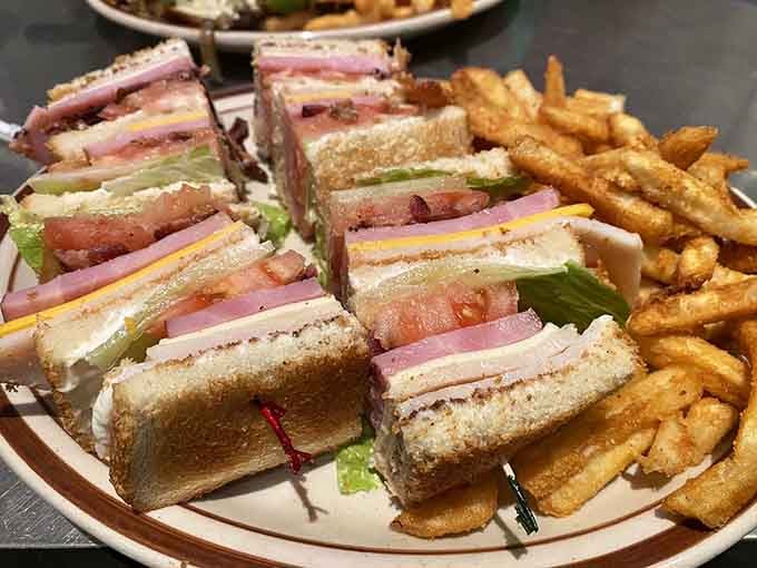 Triple-decker club sandwich cut into quarters because some meals require an engineering degree.