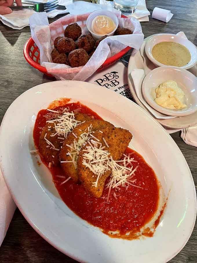 Golden fried mozzarella wedges swimming in marinara sauce, with hushpuppies providing delicious backup in the background.
