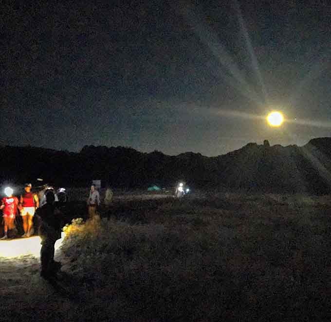 The full moon rises over the desert as hikers prepare for a journey that'll make their usual evening Netflix routine seem quaint.