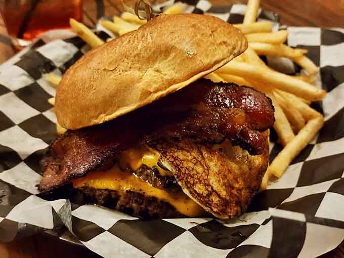 This towering burger stacks bacon and cheese like it's building a delicious fortress of flavor and joy.