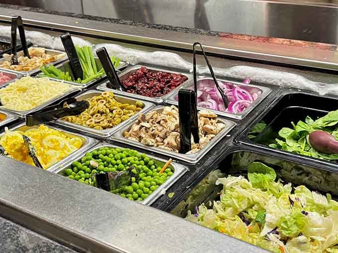 The salad bar stretches out with fresh vegetables and toppings, offering guilt-free options before you dive into the main event.
