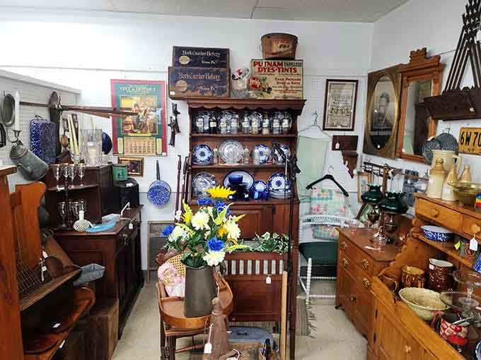 This booth bursts with treasures from wooden hutches to vintage advertising, organized chaos at its absolute finest here.