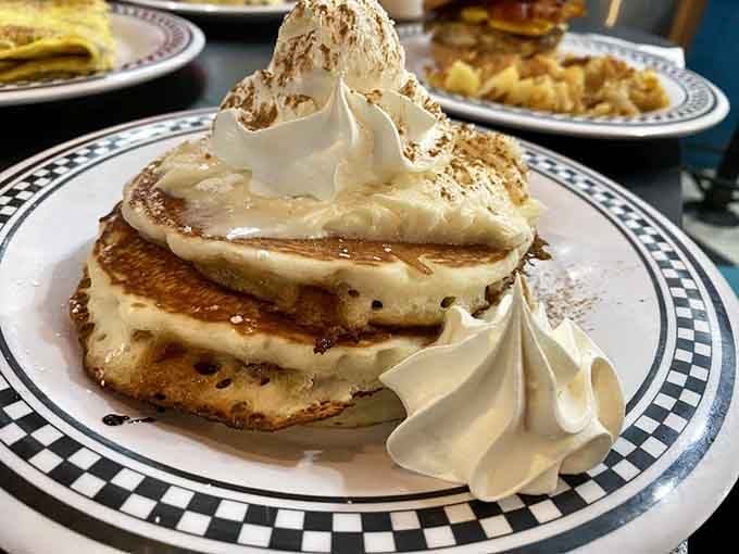 Pancakes stacked like edible architecture, crowned with whipped cream and ready to make your morning (or midnight) memorable.