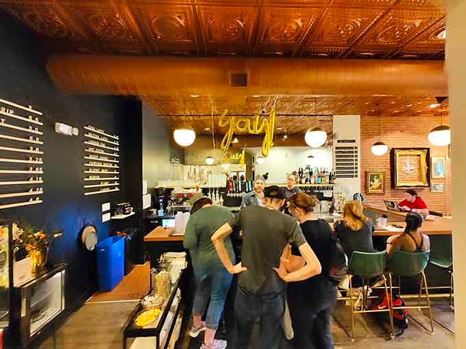 The bar counter gleams under that gorgeous tin ceiling, ready to pour whatever helps you get through your current read.