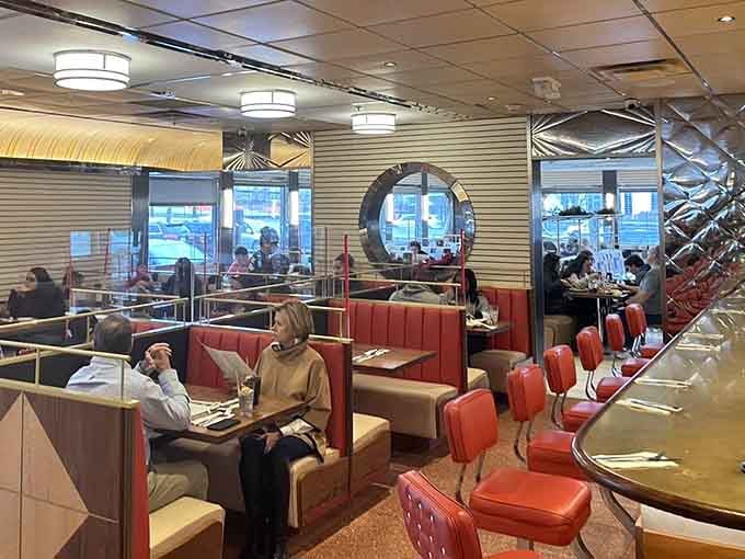 Circular windows and classic booths create a retro atmosphere that makes every meal feel like a special occasion.