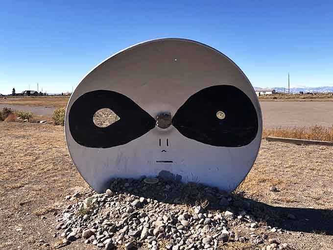 That alien face sculpture stares knowingly across the desert, like it's seen some things it can't discuss.