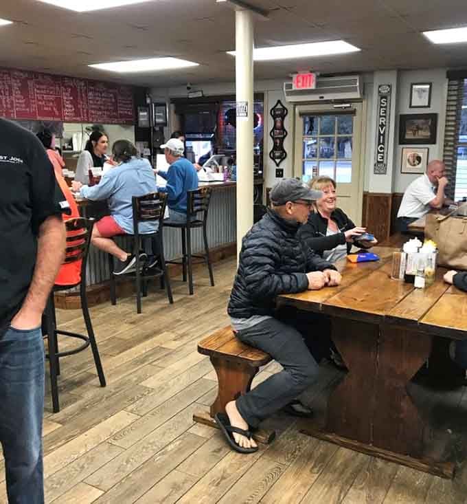Happy diners at communal tables prove that great barbecue brings people together better than any social media algorithm ever could.