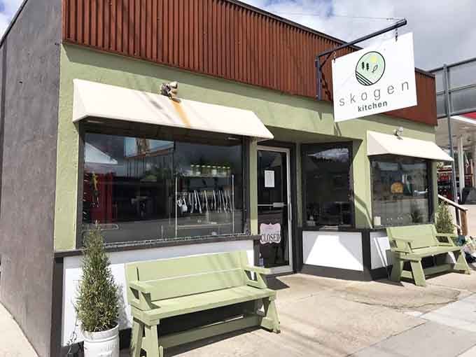 The mint-green exterior and welcoming benches say "come sit a spell" in the universal language of small-town hospitality.