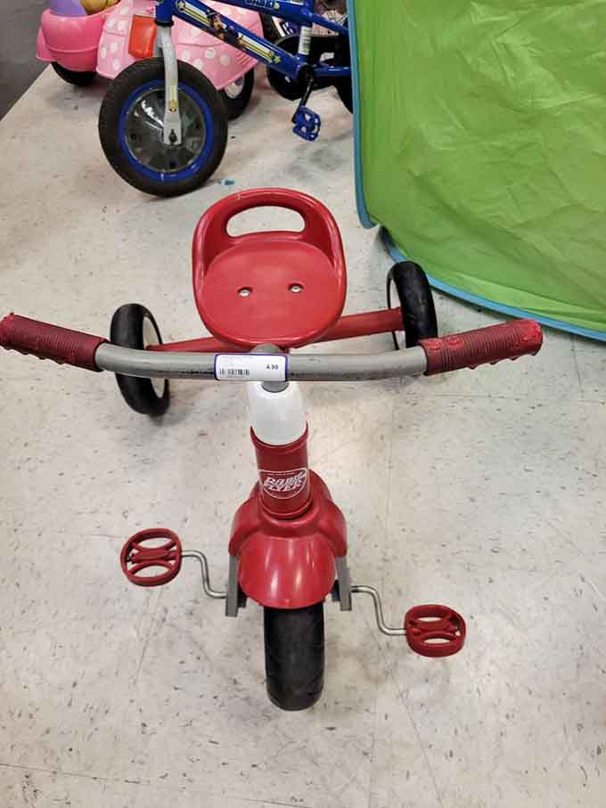 A little red trike that's seen some miles but has plenty more adventures ahead. Some kid is about to have the best day ever.