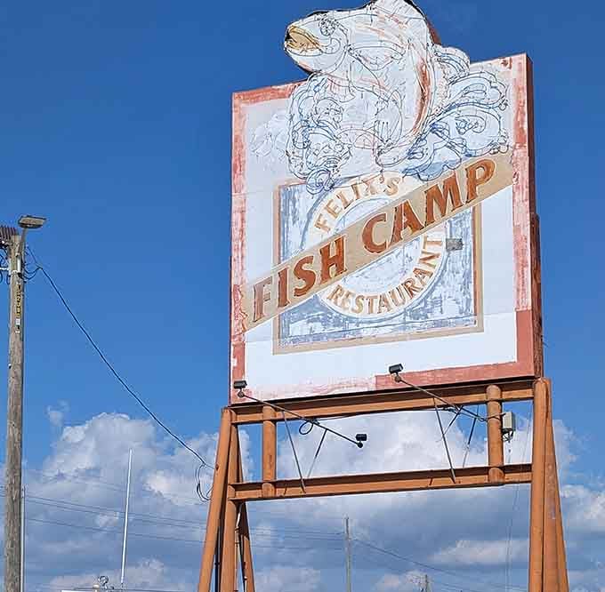 The weathered sign stands like a lighthouse for hungry travelers, promising seafood salvation just beyond the parking lot.
