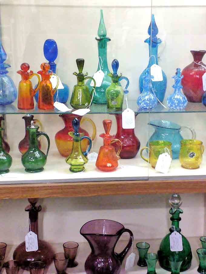 Colorful vintage glassware catches light beautifully, transforming ordinary shelves into rainbow displays of craftsmanship.